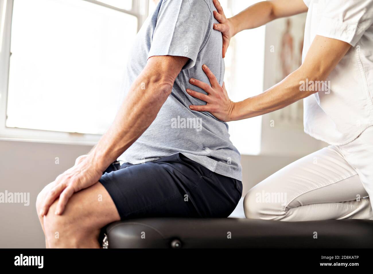 A Modern rehabilitation physiotherapy worker with senior client Stock ...