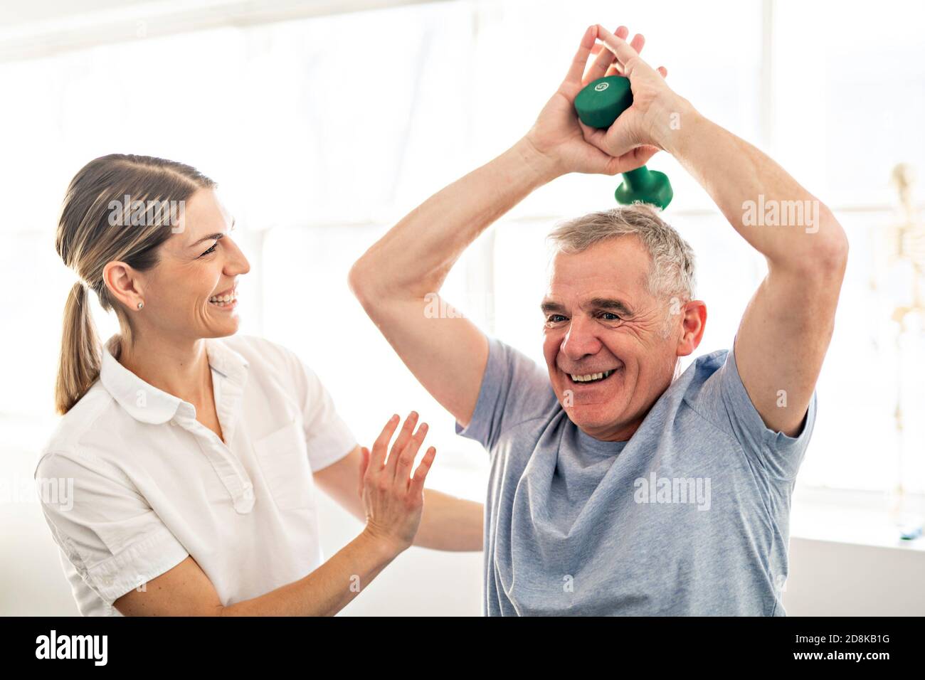 A Modern rehabilitation physiotherapy worker with senior client Stock ...