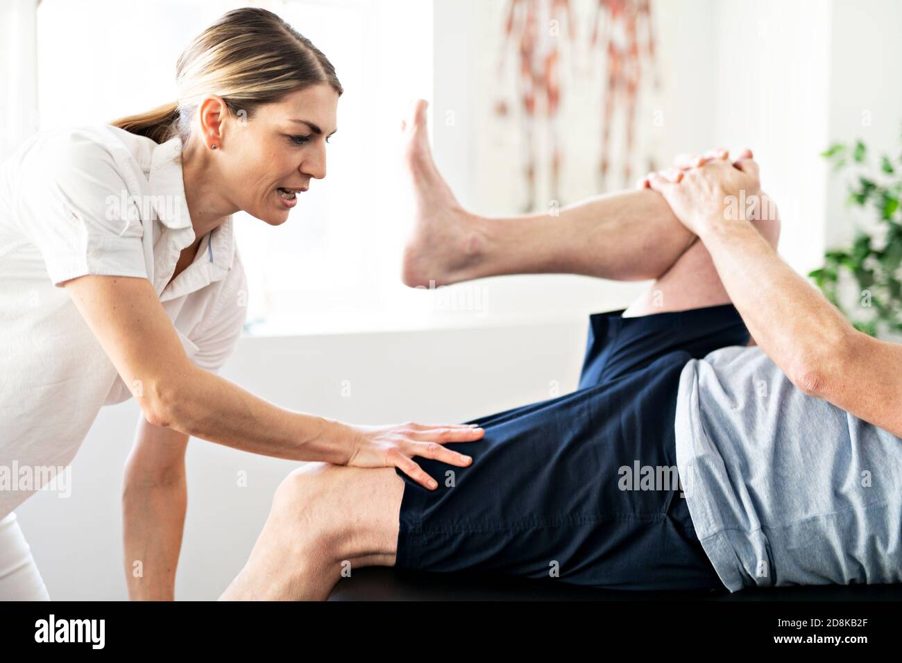 A Modern rehabilitation physiotherapy worker with senior client Stock ...