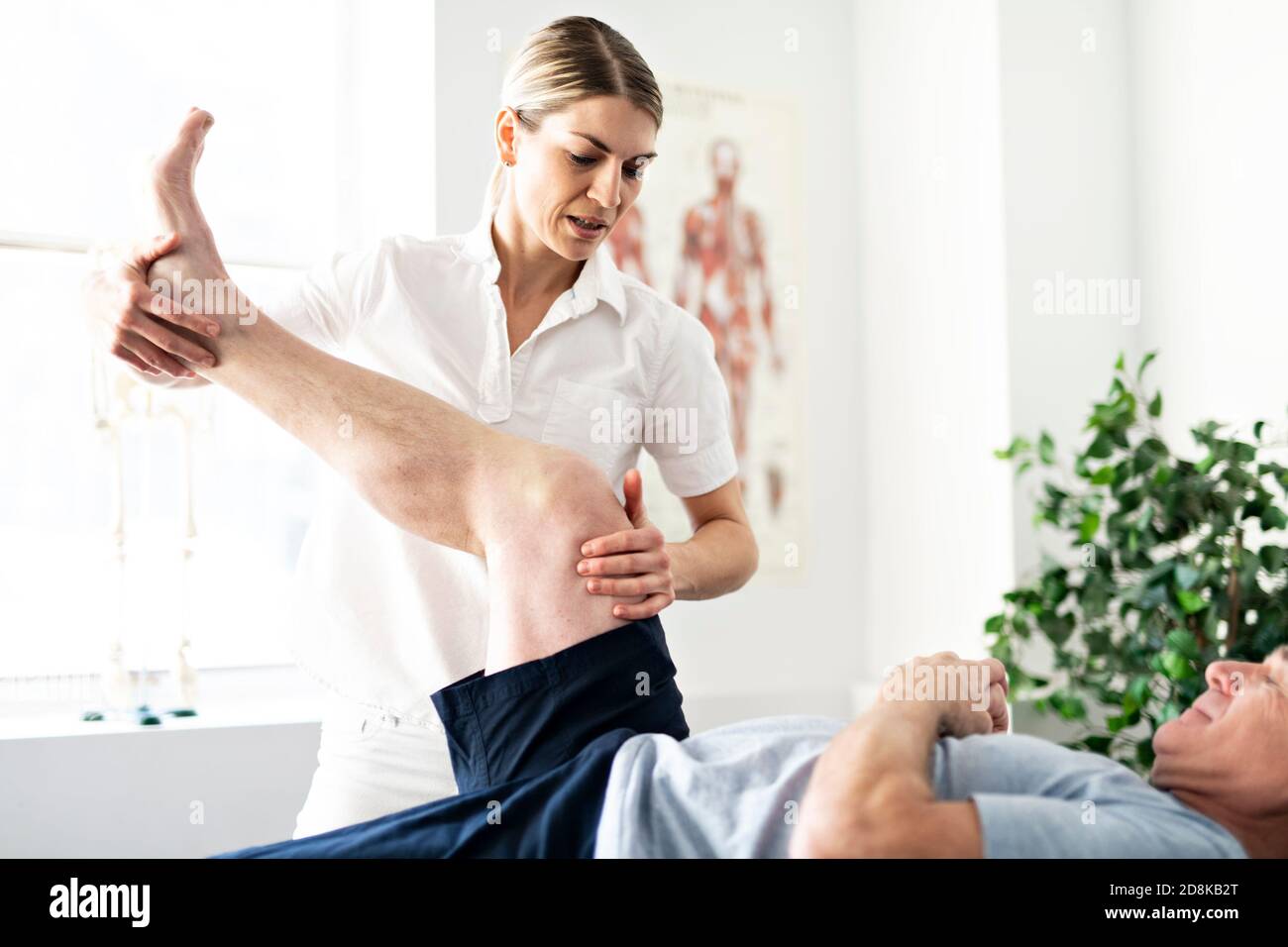 A Modern rehabilitation physiotherapy worker with senior client Stock ...
