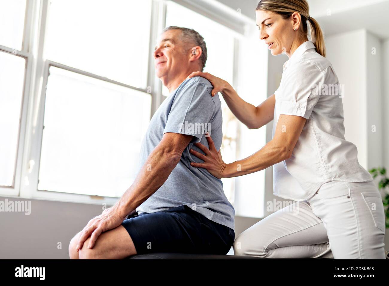 A Modern rehabilitation physiotherapy worker with senior client Stock ...