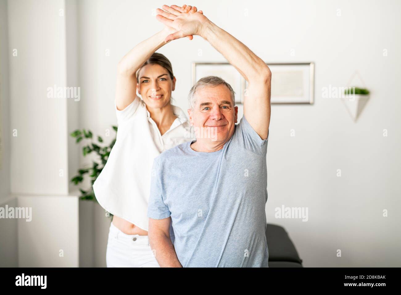 A Modern rehabilitation physiotherapy worker with senior client Stock ...