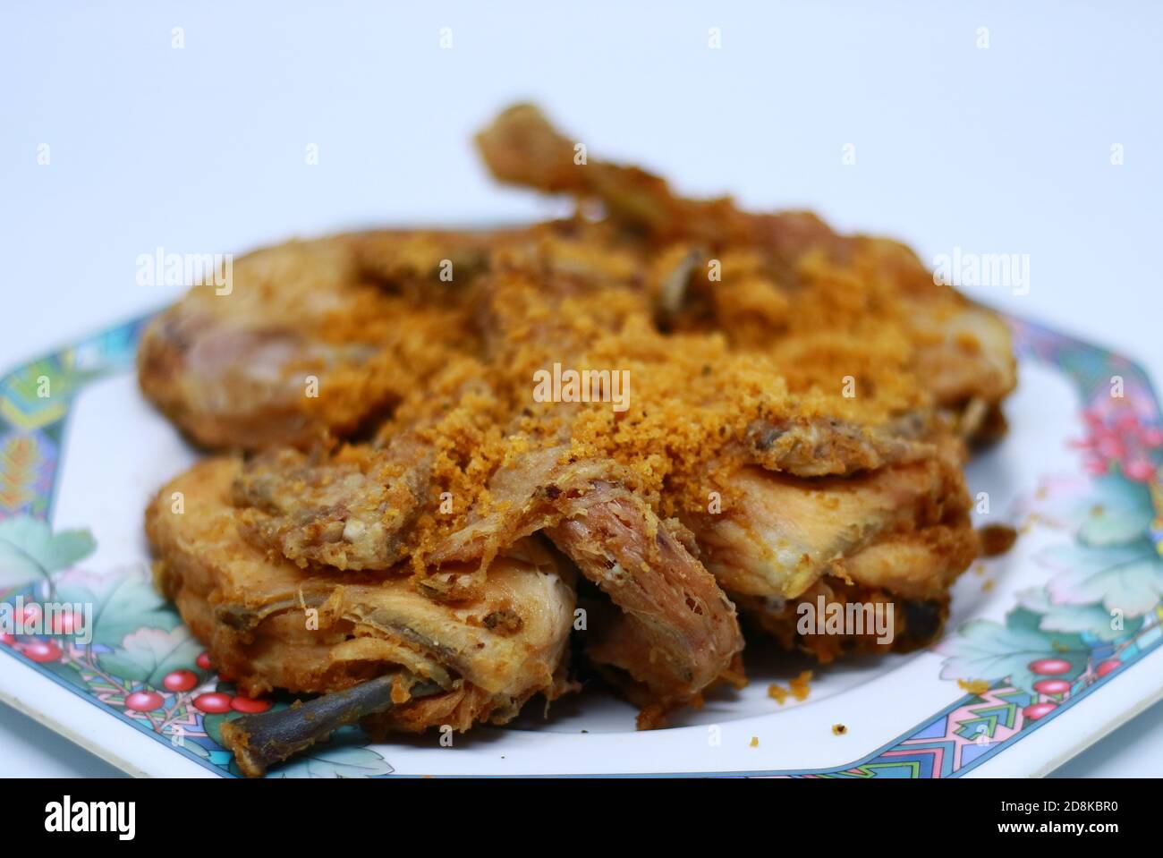 Fried chicken with crispy spiced flakes on white background. Indonesian ...