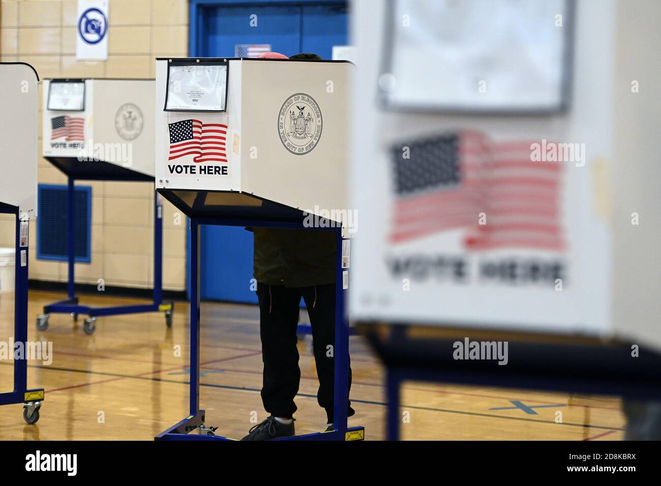 New York City, USA. 30th Oct, 2020. People stand behind a voter privacy ...