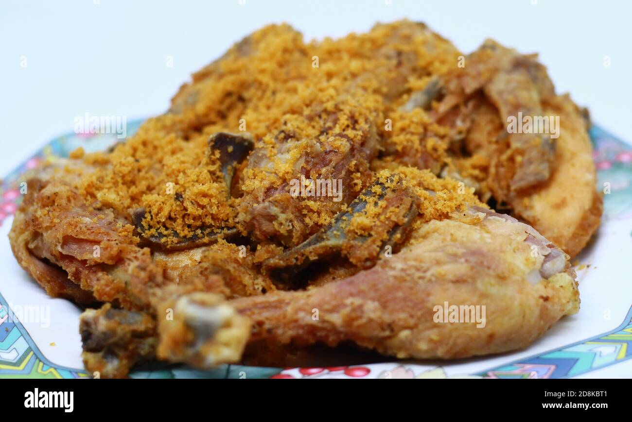 Fried chicken with crispy spiced flakes on white background. Indonesian ...