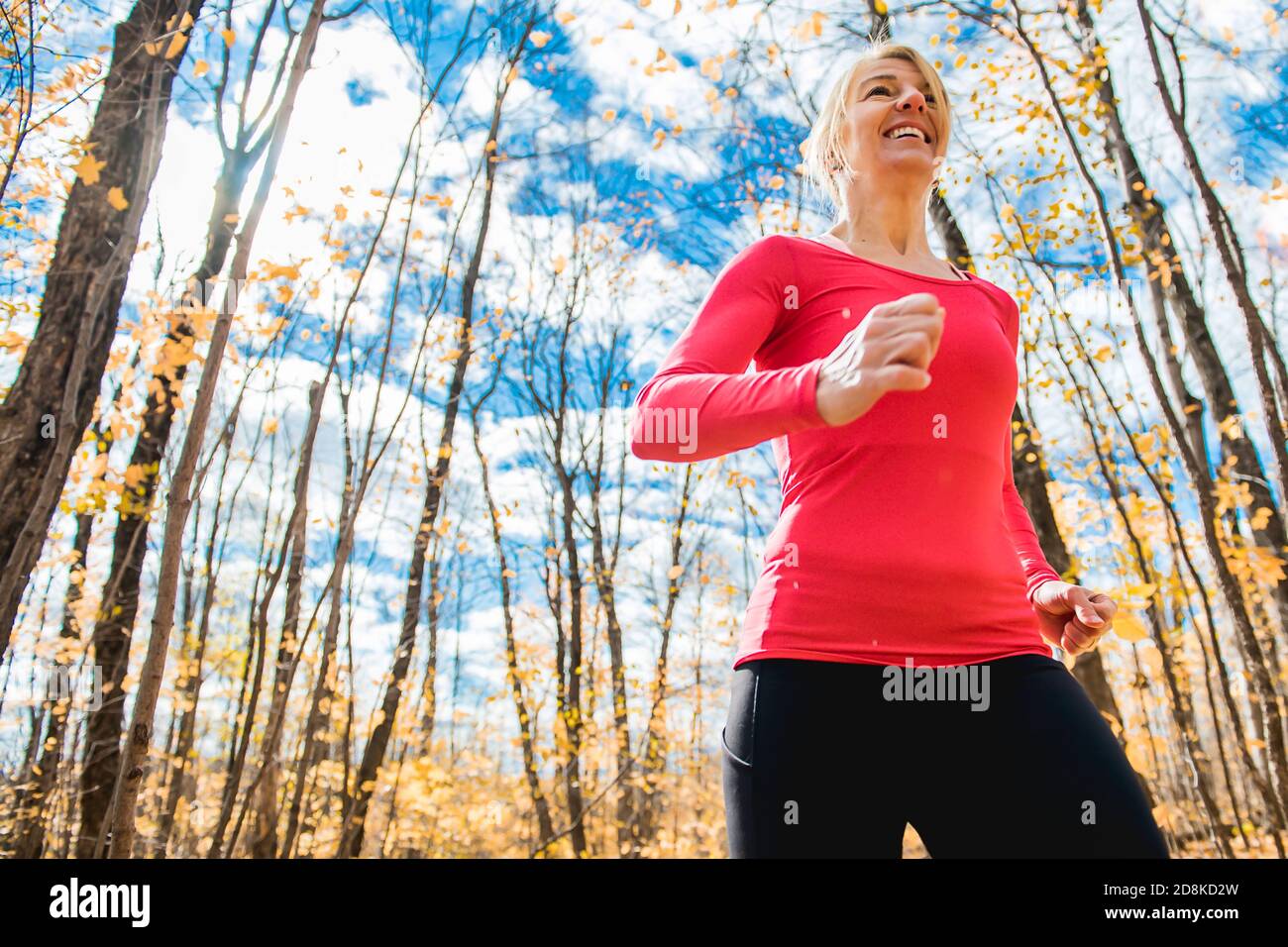 A Bautiful running woman jogging in autumn nature Stock Photo - Alamy