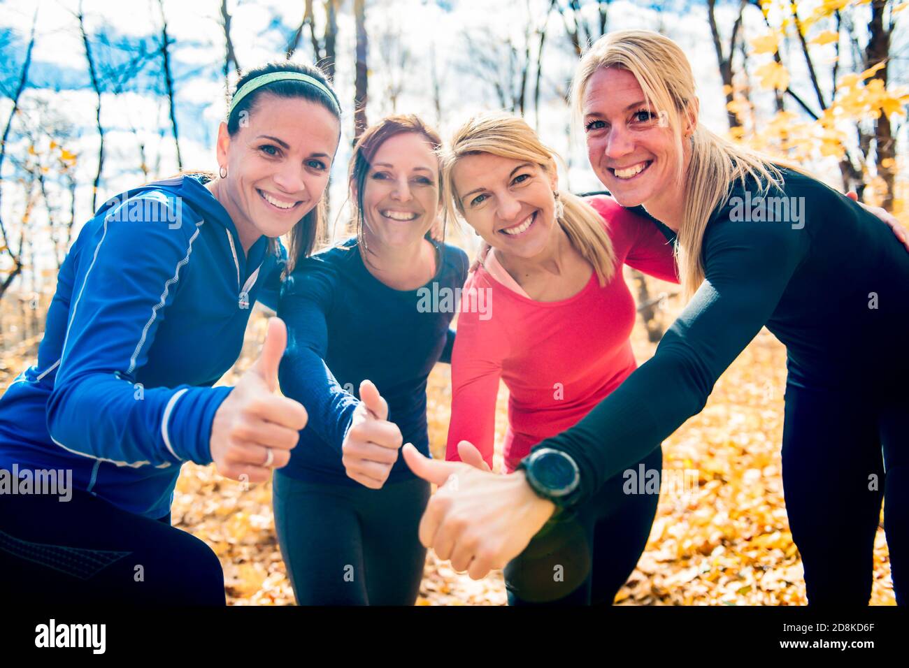 woman group out running together in an autumn park they run a race or ...