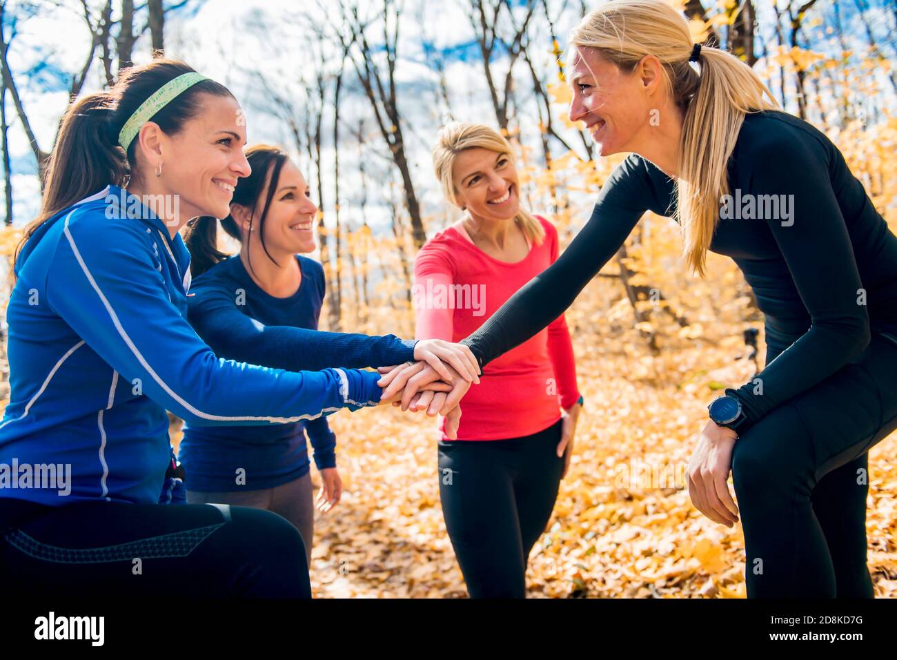 woman group out running together in an autumn park they run a race or ...