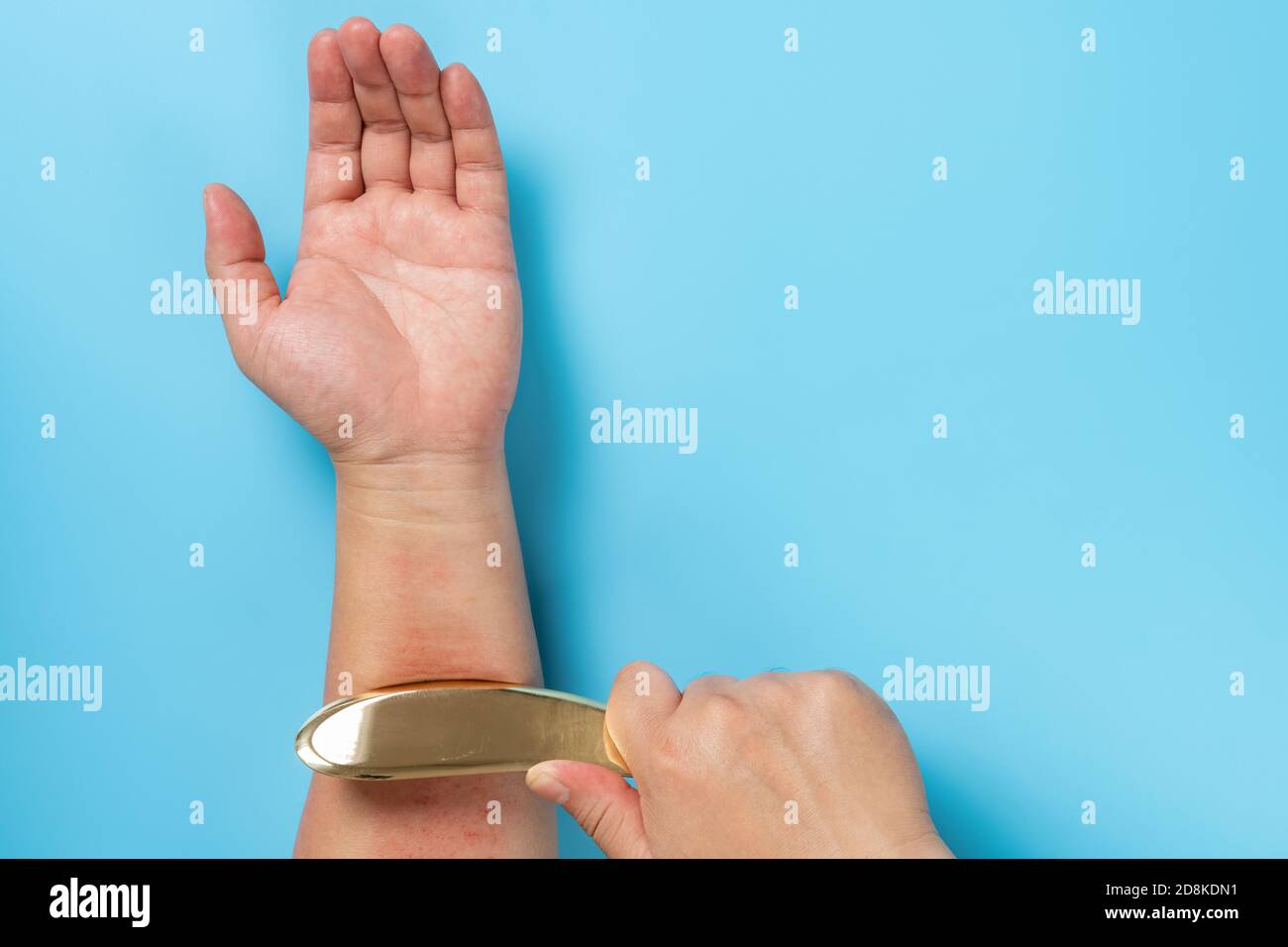 man scraping his arm by a copper scratcher which is a traditional ...