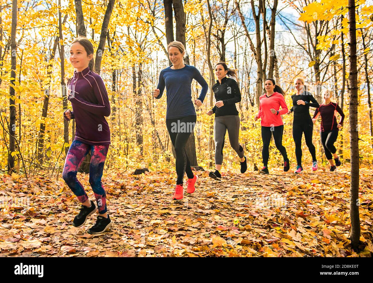 woman group out running together in an autumn park they run a race or ...