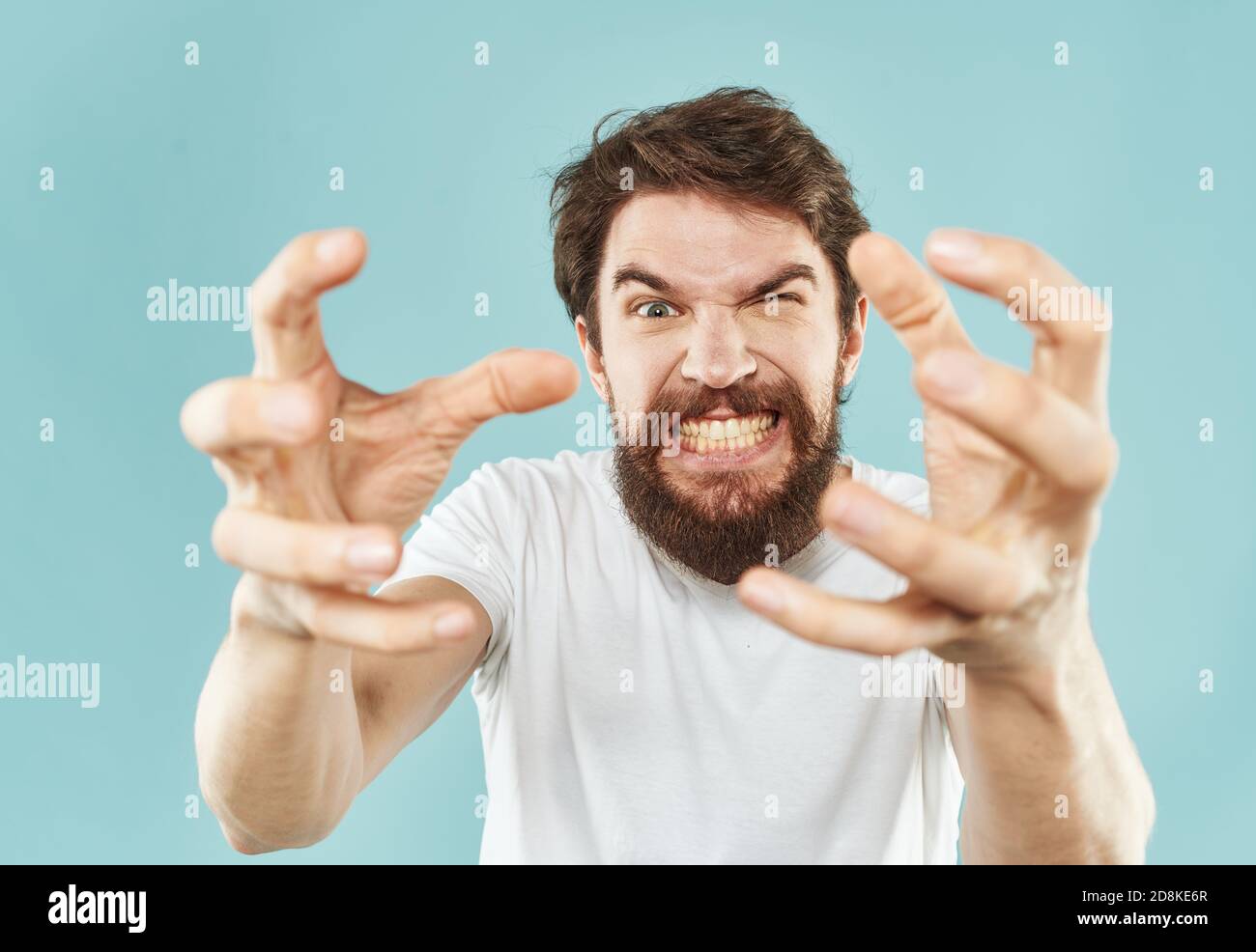 Impulsive man on a blue background gestures with his hands irritability stress Stock Photo - Alamy