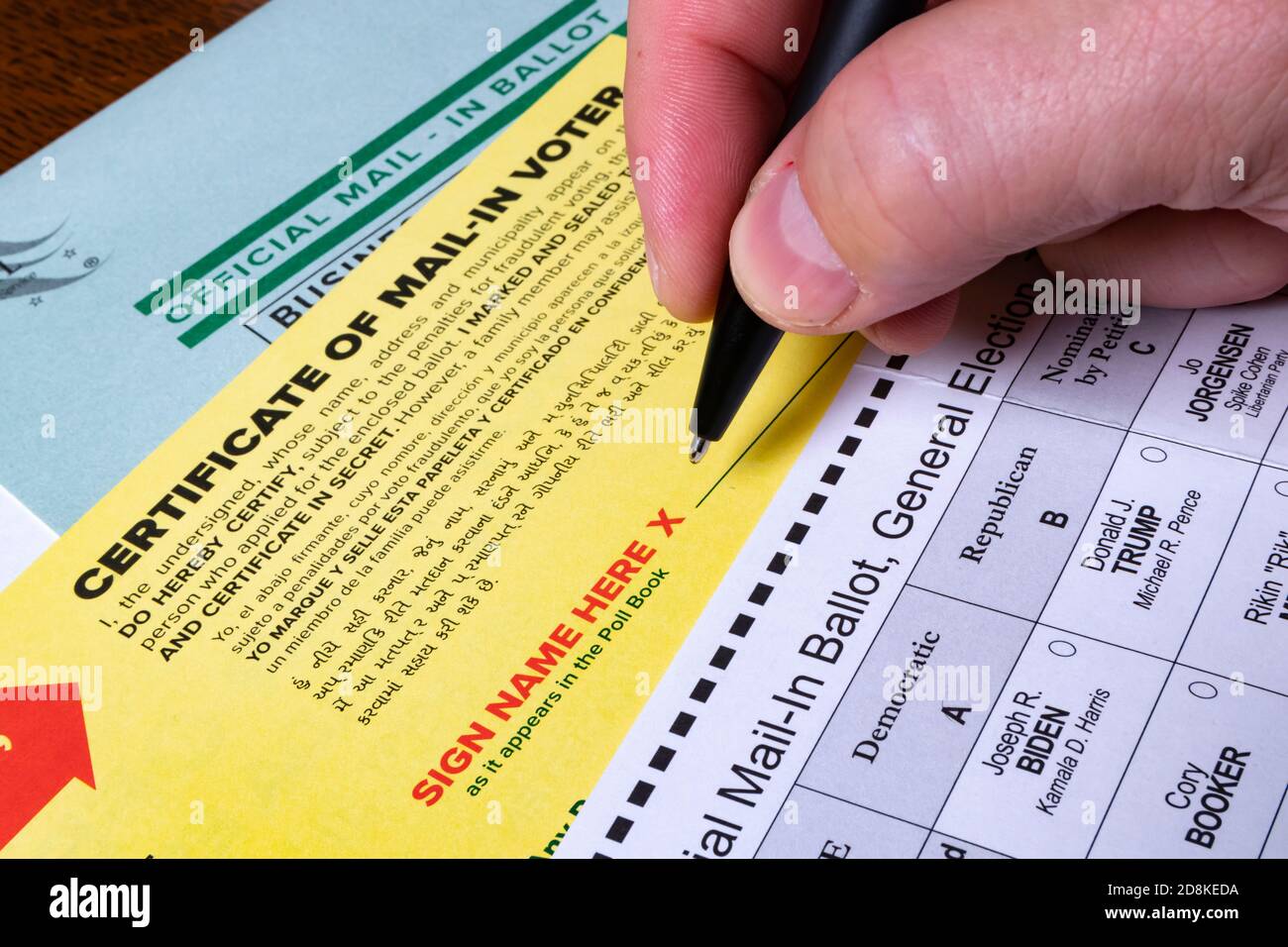 Hand prepares to sign signature on official mail-in ballot for 2020 US ...
