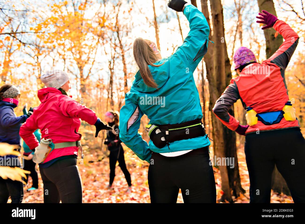 woman group out running together in an autumn park they run a race or ...