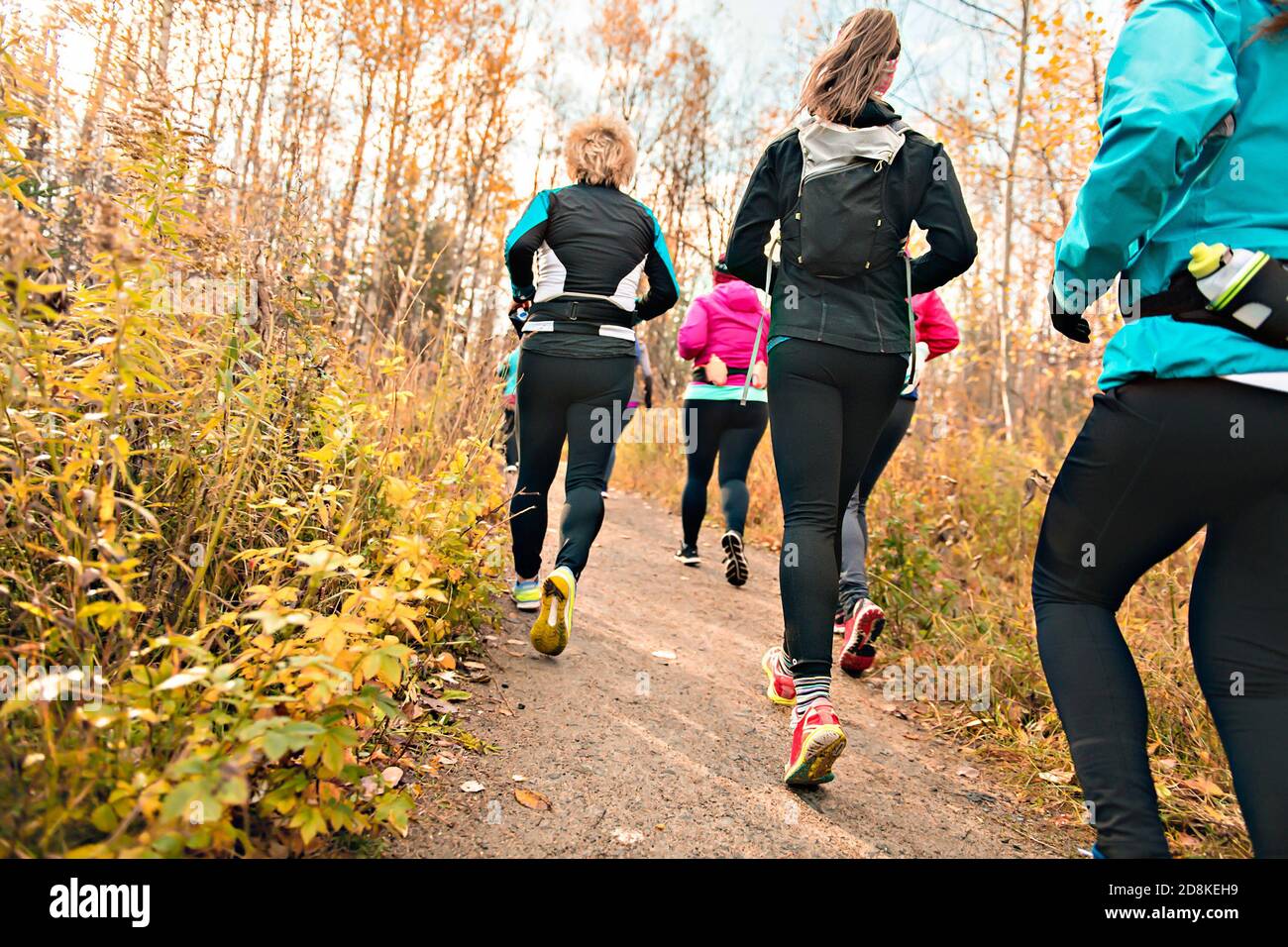 woman group out running together in an autumn park they run a race or ...