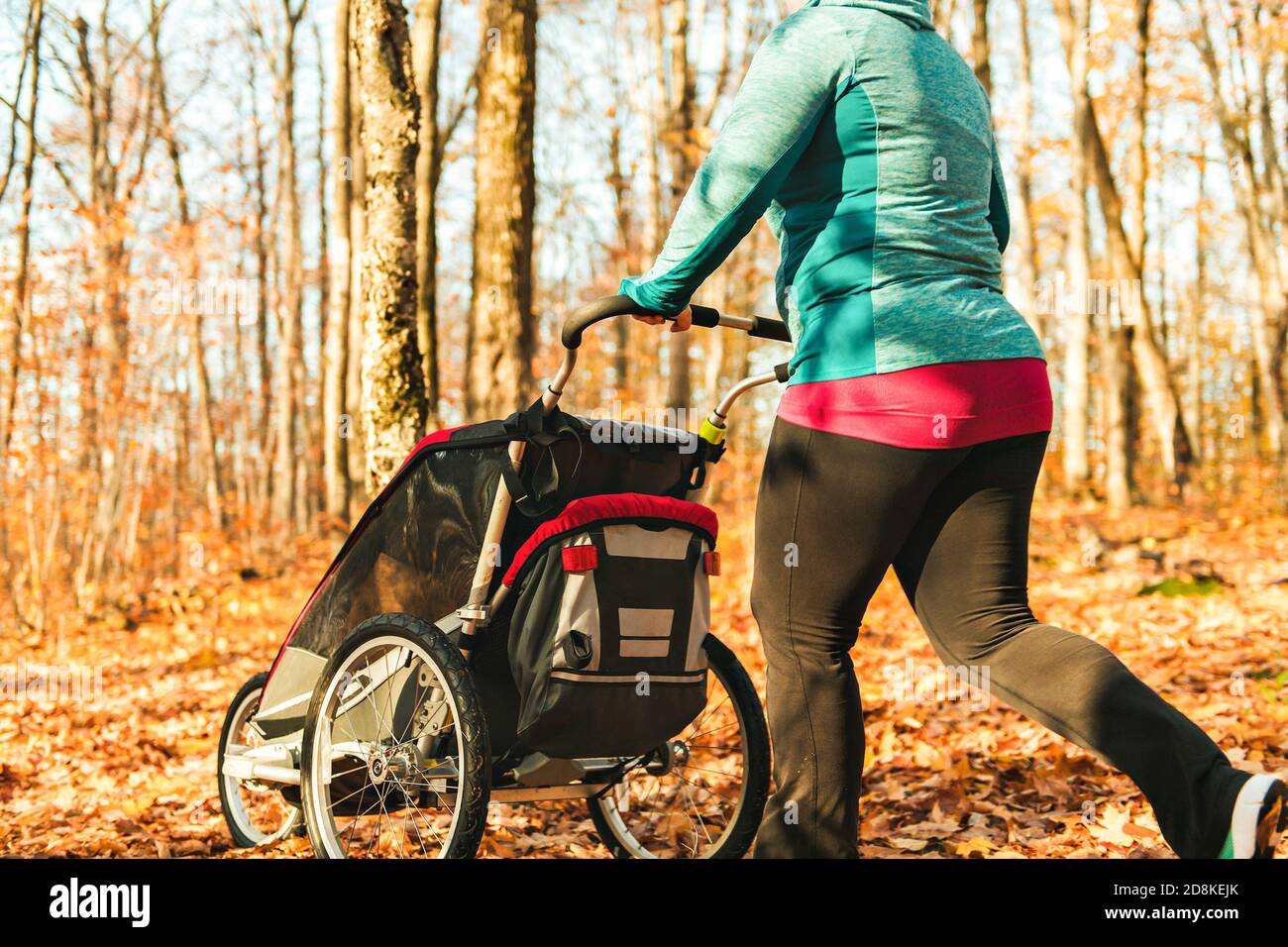 Stroller woman running in an autumn park they run a race or train in a ...