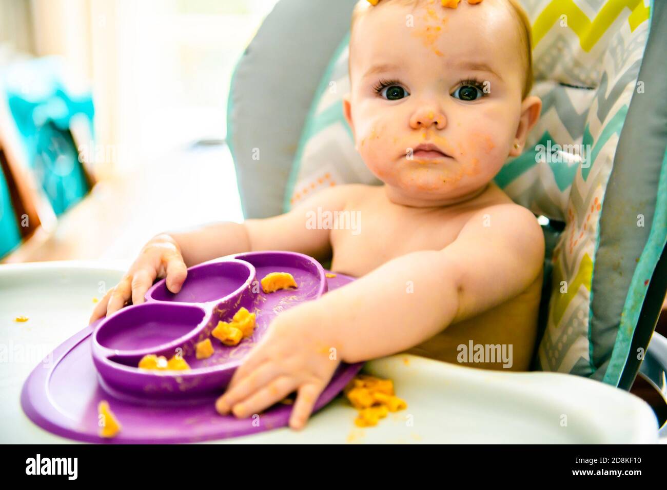 Little baby eating her dinner and making a mess Stock Photo - Alamy