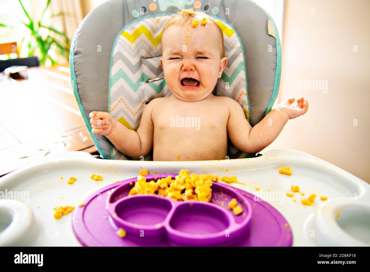 Little baby eating her dinner and making a mess Stock Photo - Alamy