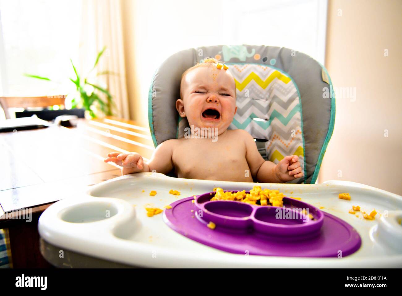 Little baby eating her dinner and making a mess Stock Photo - Alamy