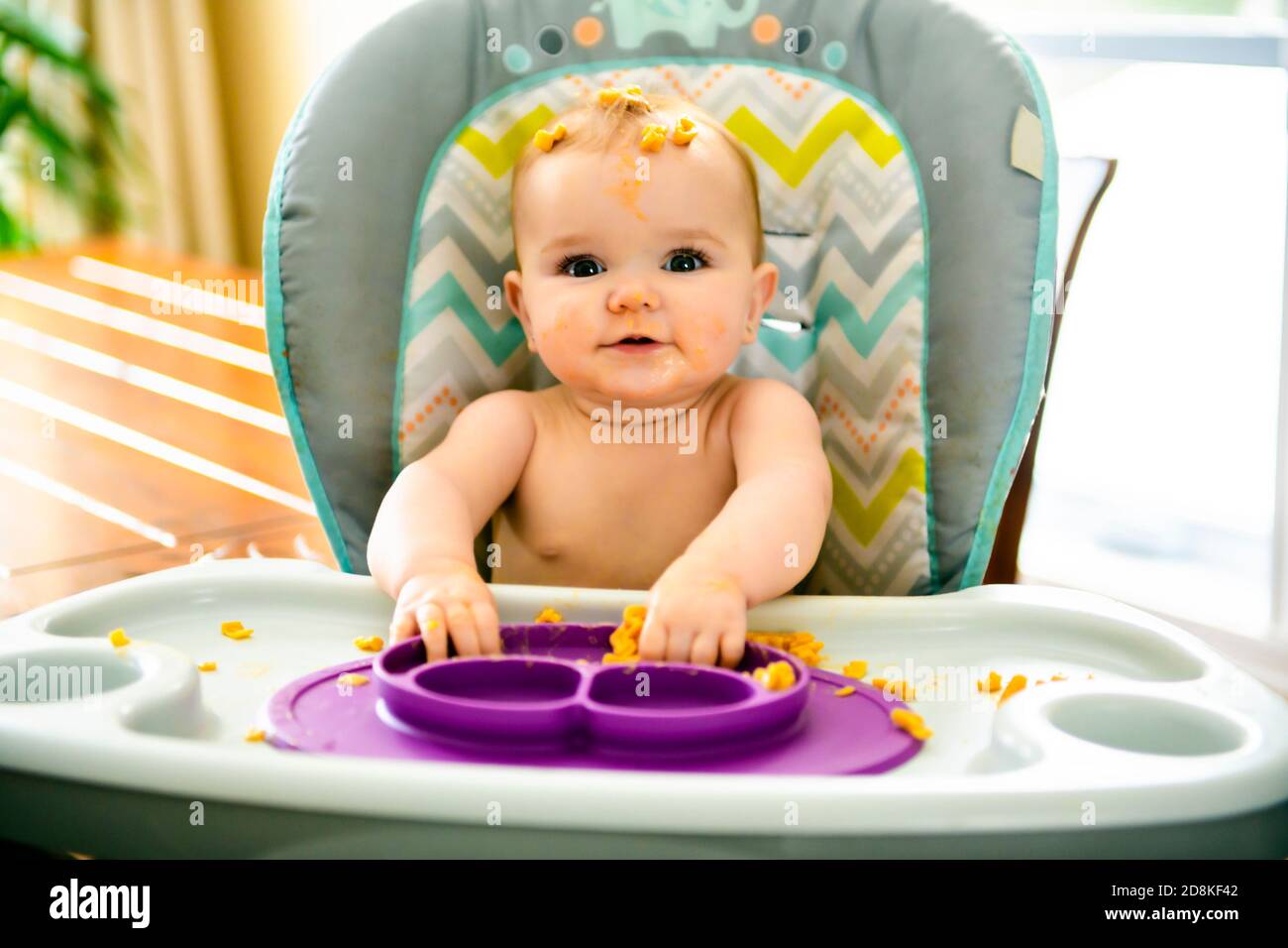 Little baby eating her dinner and making a mess Stock Photo - Alamy