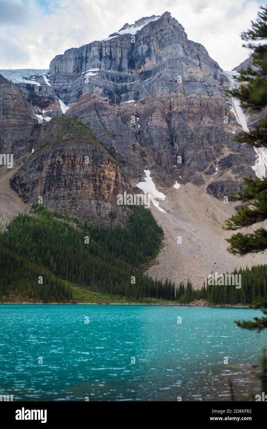 Vertical shot of rocky mountains behind the turquoise glacial lakes in ...