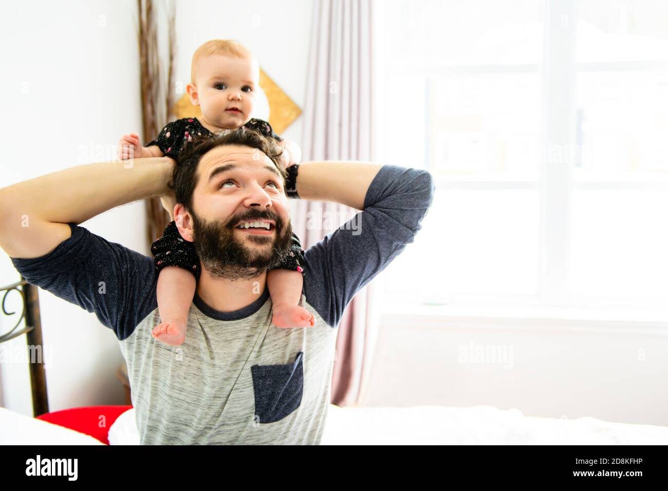 Young happy father playing with baby on bed Stock Photo - Alamy