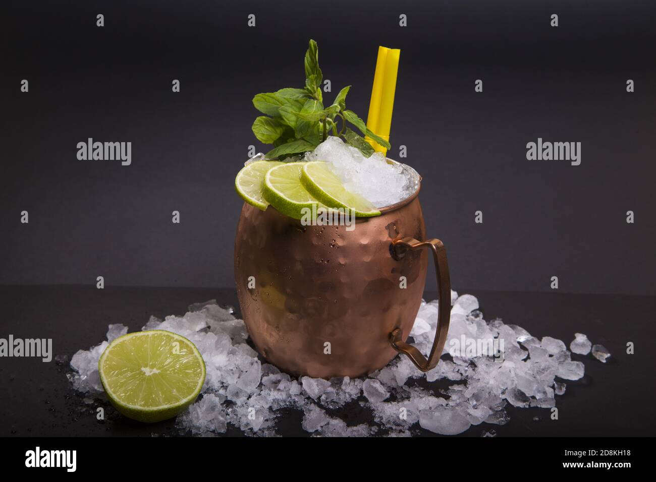 Closeup shot of a drink made with lime, mint leaves and ice on a black ...