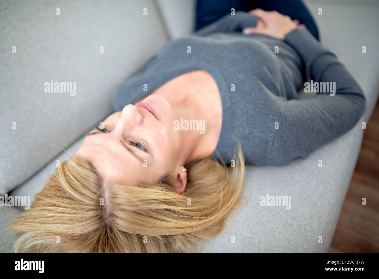Relaxed woman enjoying rest on comfortable sofa, calm attractive girl ...