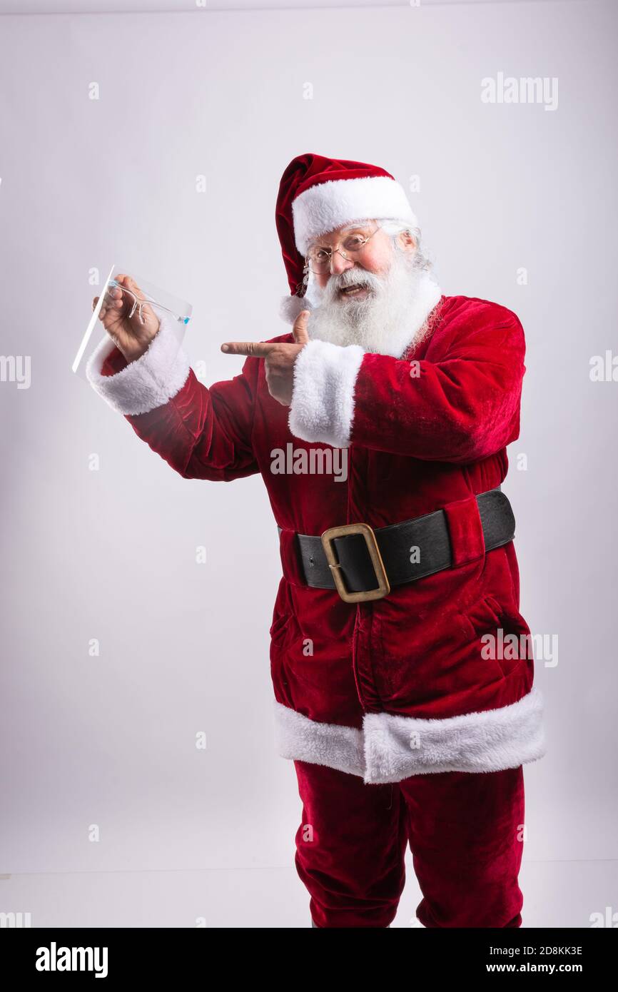 Happy Smart Santa Claus, pointing a face shield in white background ...