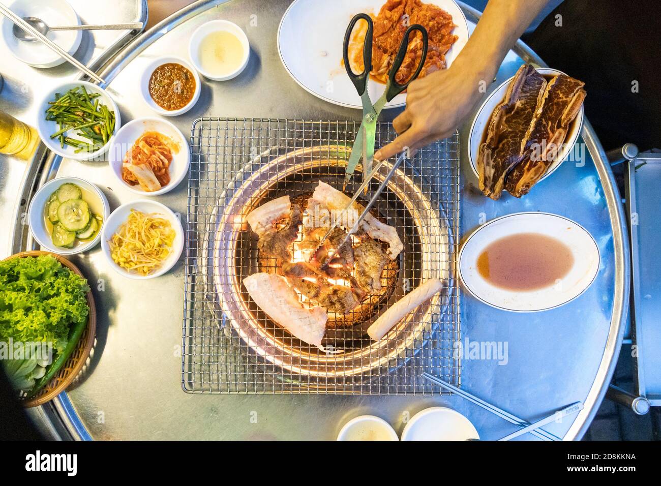 Overhead view of Korean barbecue being grilled, with other dishes Stock ...
