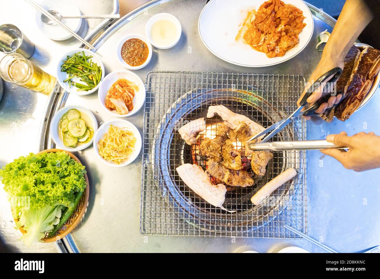 Overhead view of Korean barbecue being grilled, with other dishes Stock ...