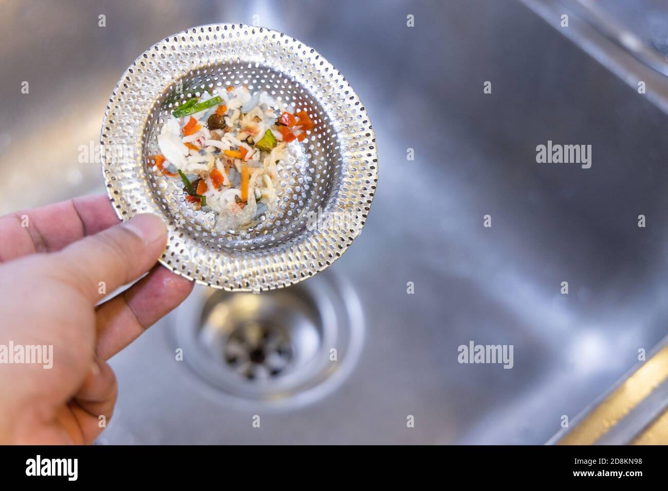 Hand holding kitchen sink waste filter with trapped food waste Stock ...