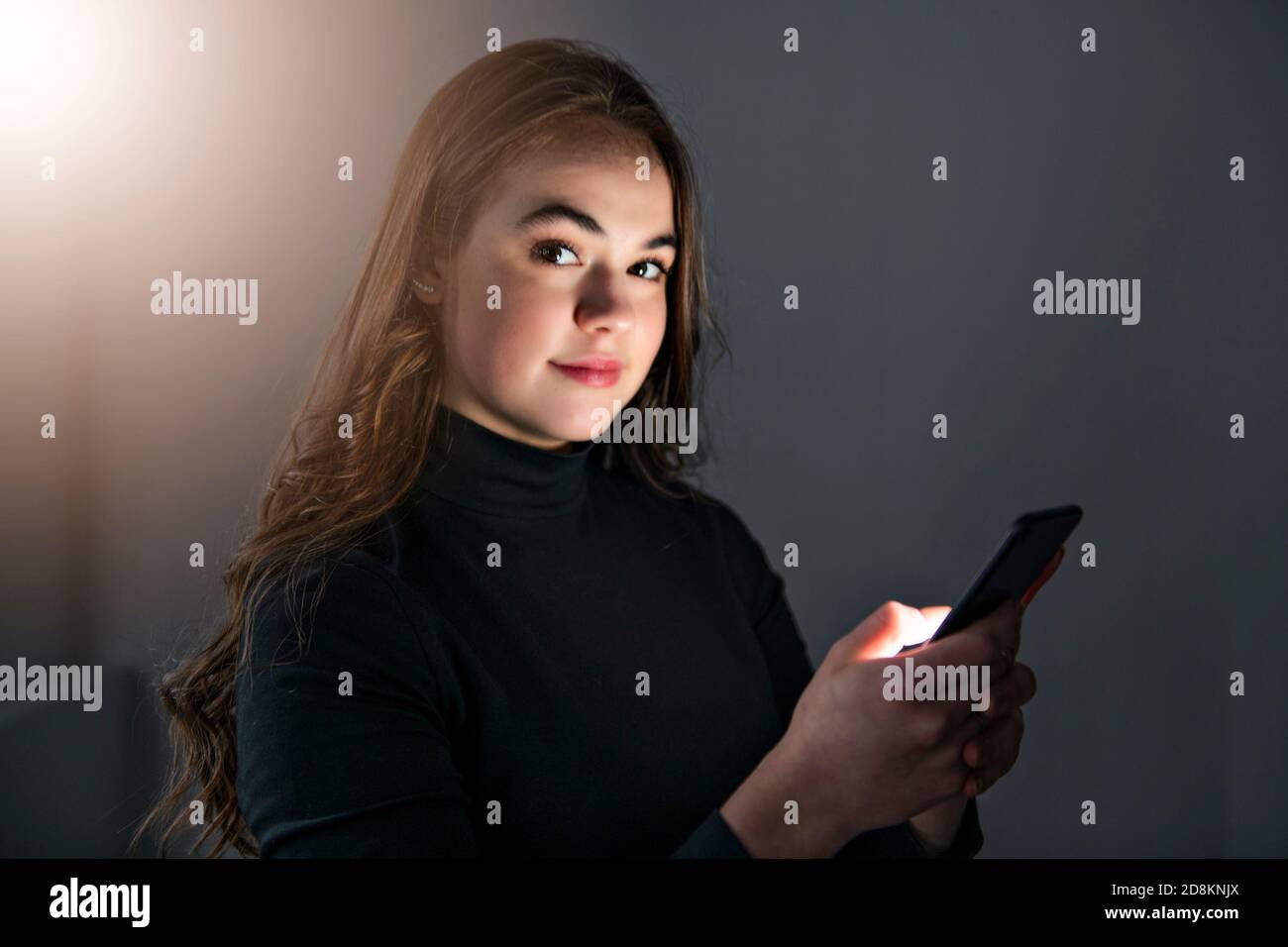 A young teenager girl using mobile phone in dark room Stock Photo - Alamy
