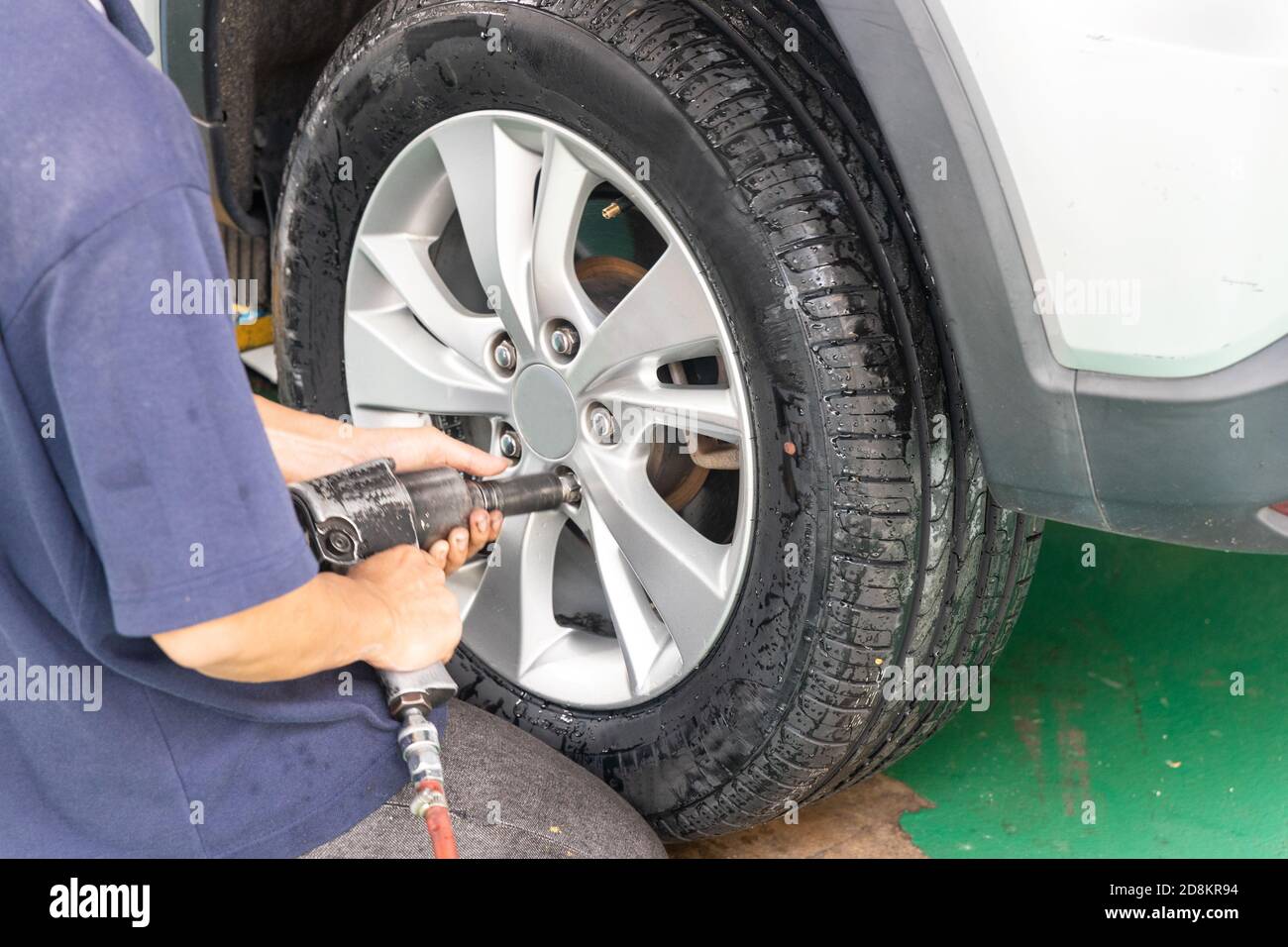 Worker removing fixing tire of wheel onto car Stock Photo - Alamy