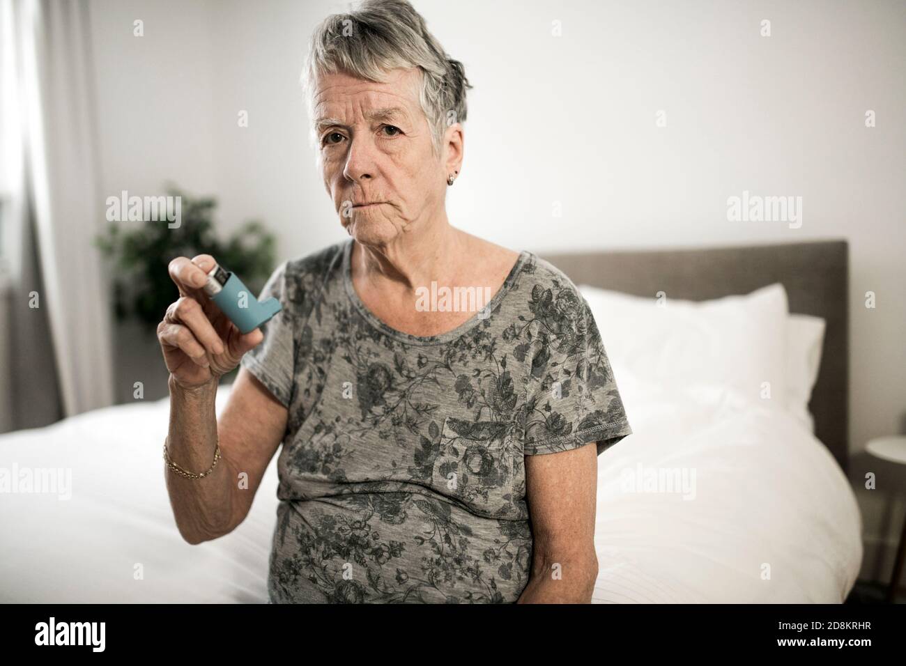 old senior woman use inhaler medicine old asthma patient in bedroom ...