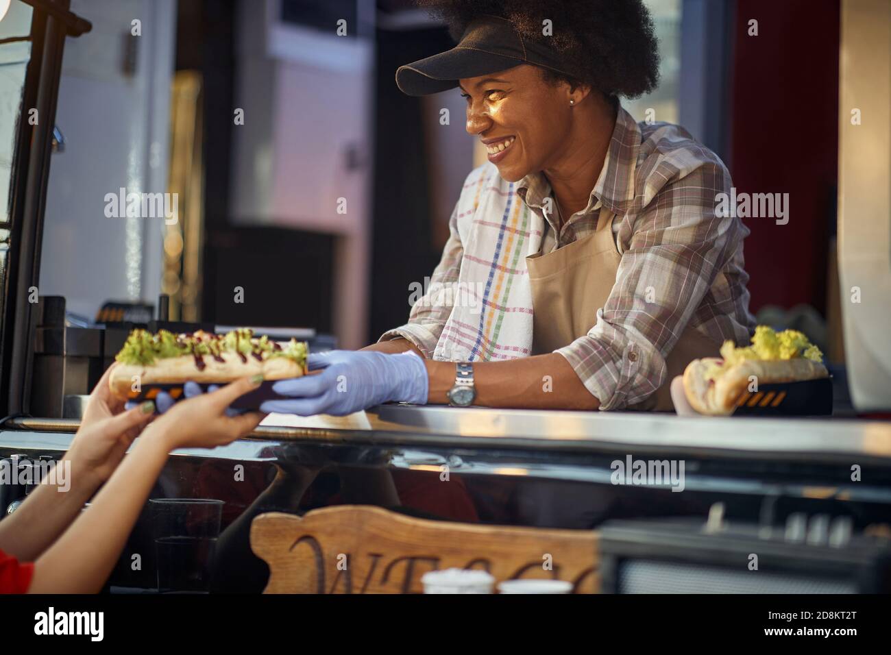 afro-american female employee in fast food service giving ordered ...