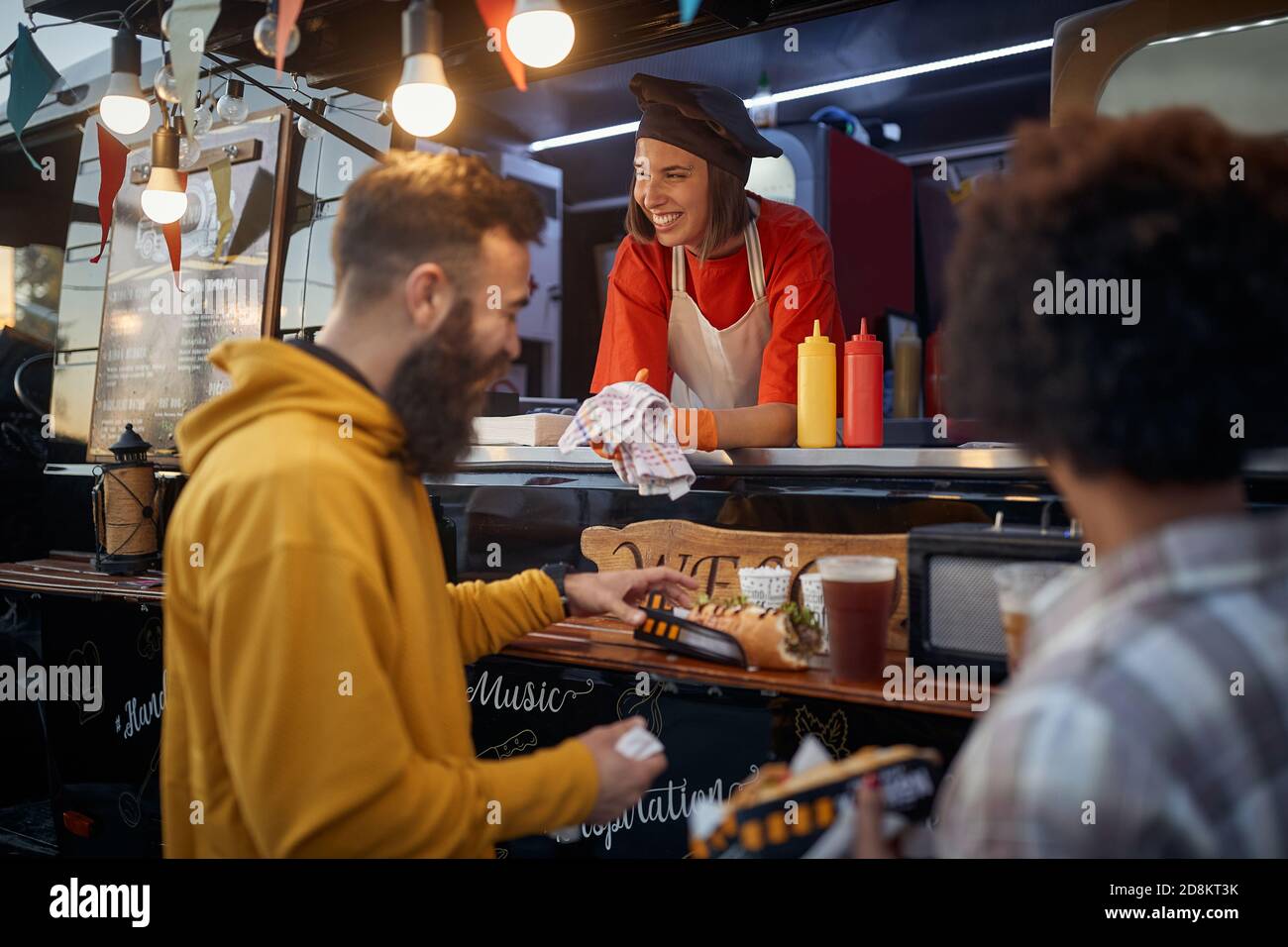young hipster is about to eat sandwich on front of fast food service ...