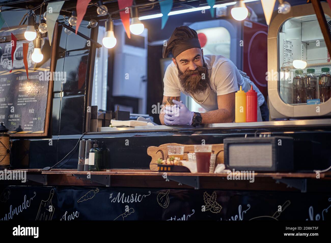 young male employee in fast food service waiting for customers leaned ...