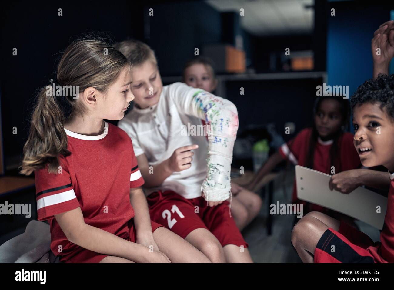 A little player showing his injury to a little teammate at the locker ...