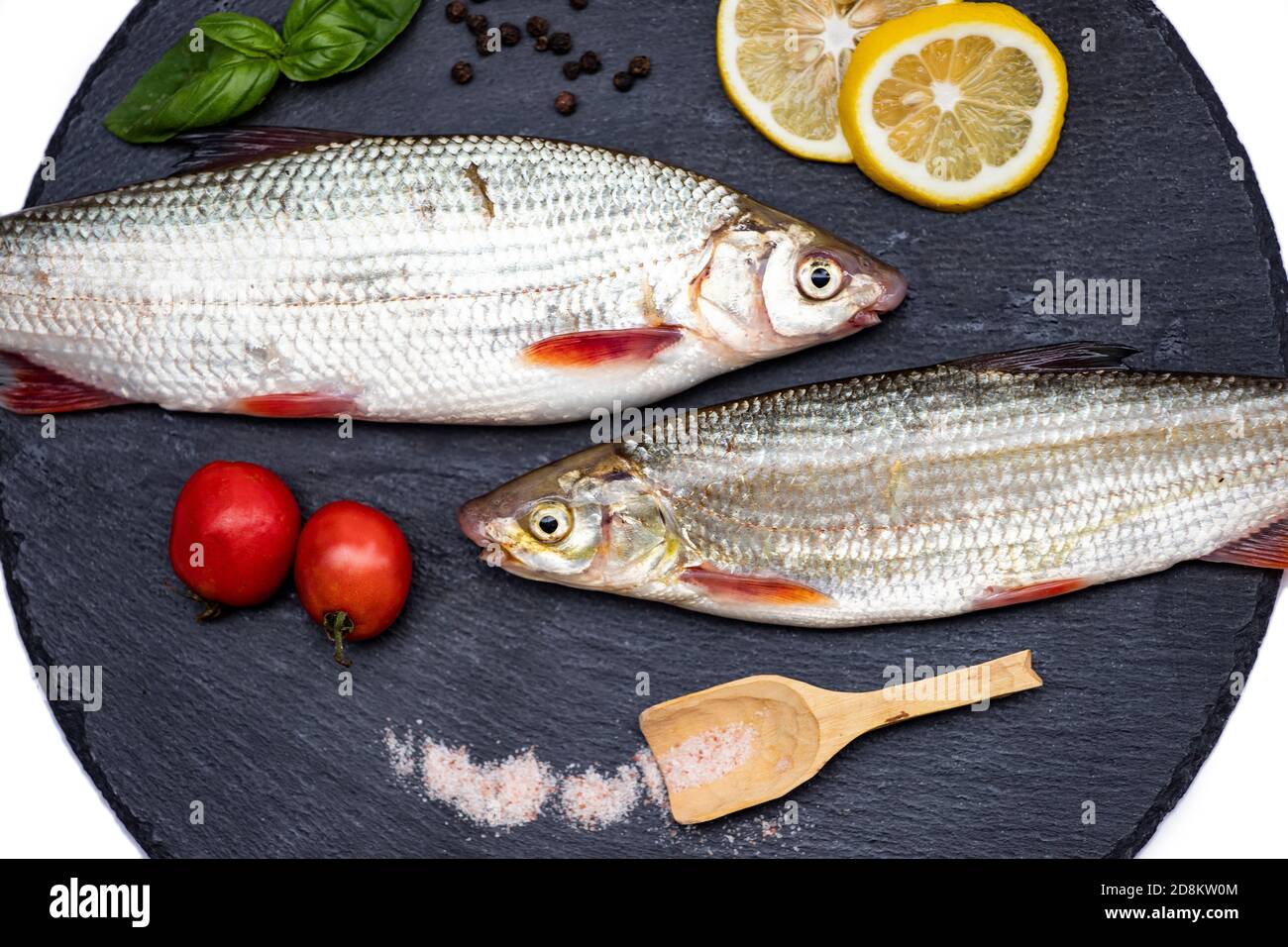 Raw fresh fish spices and herbs ingredients for cooking on black stone ...