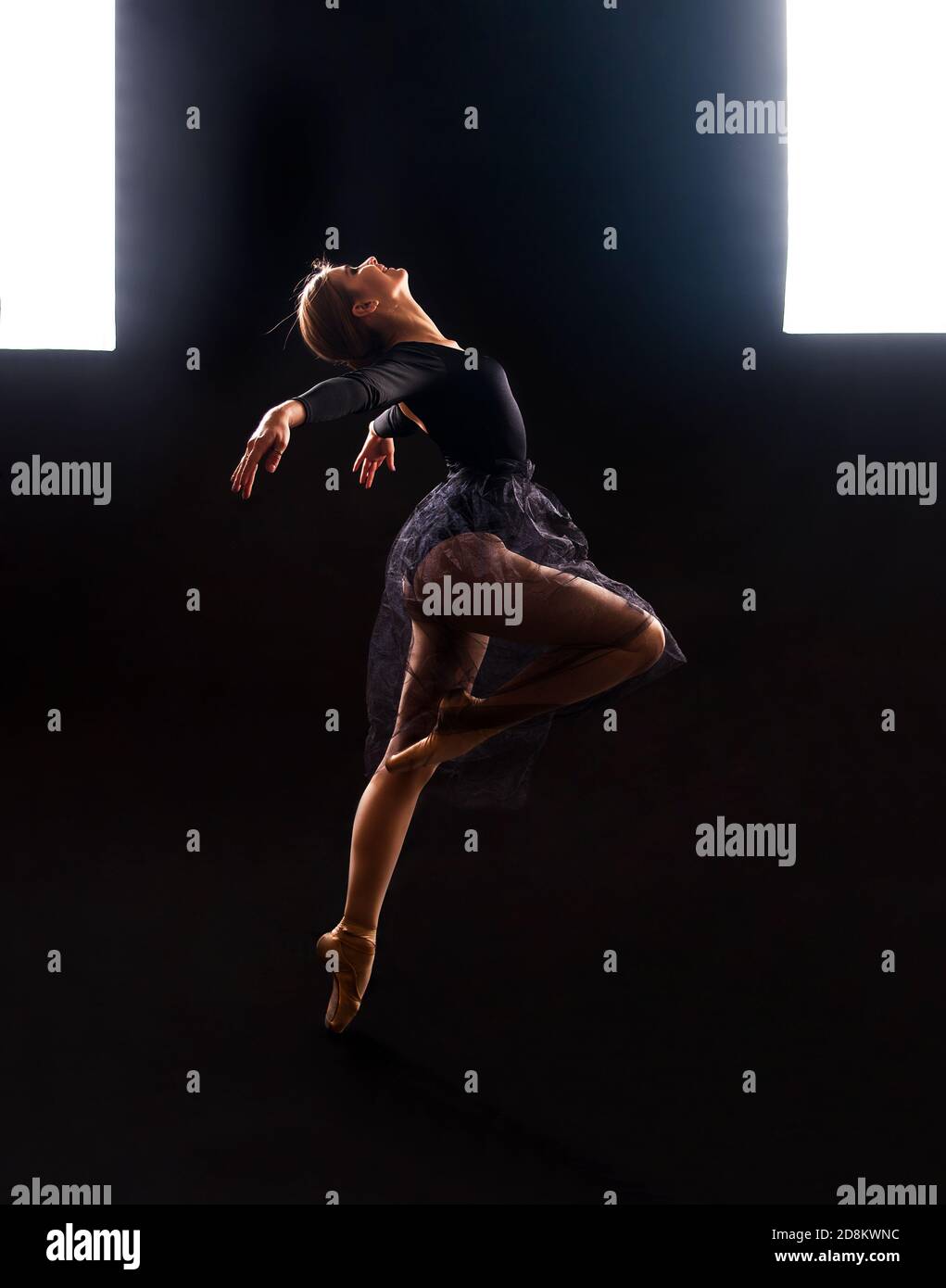 Charming woman ballerina in a black suit, is dancing a ballet in the ...