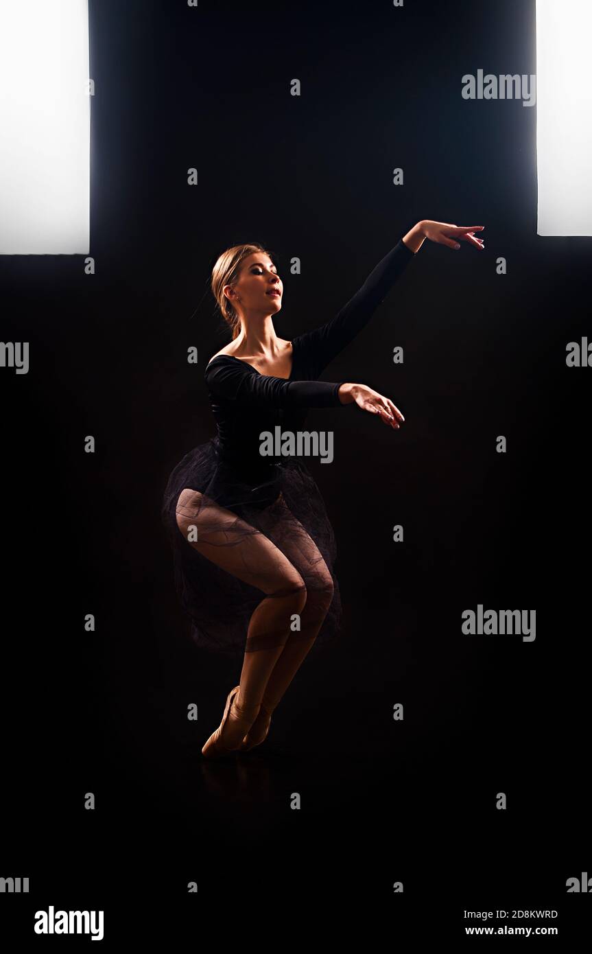 Charming woman ballerina in a black suit, is dancing a ballet in the ...