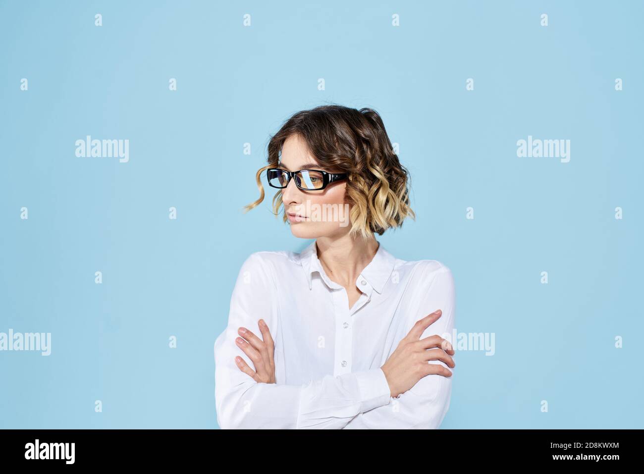 Business woman on a blue background glasses with dark rims curly hair ...