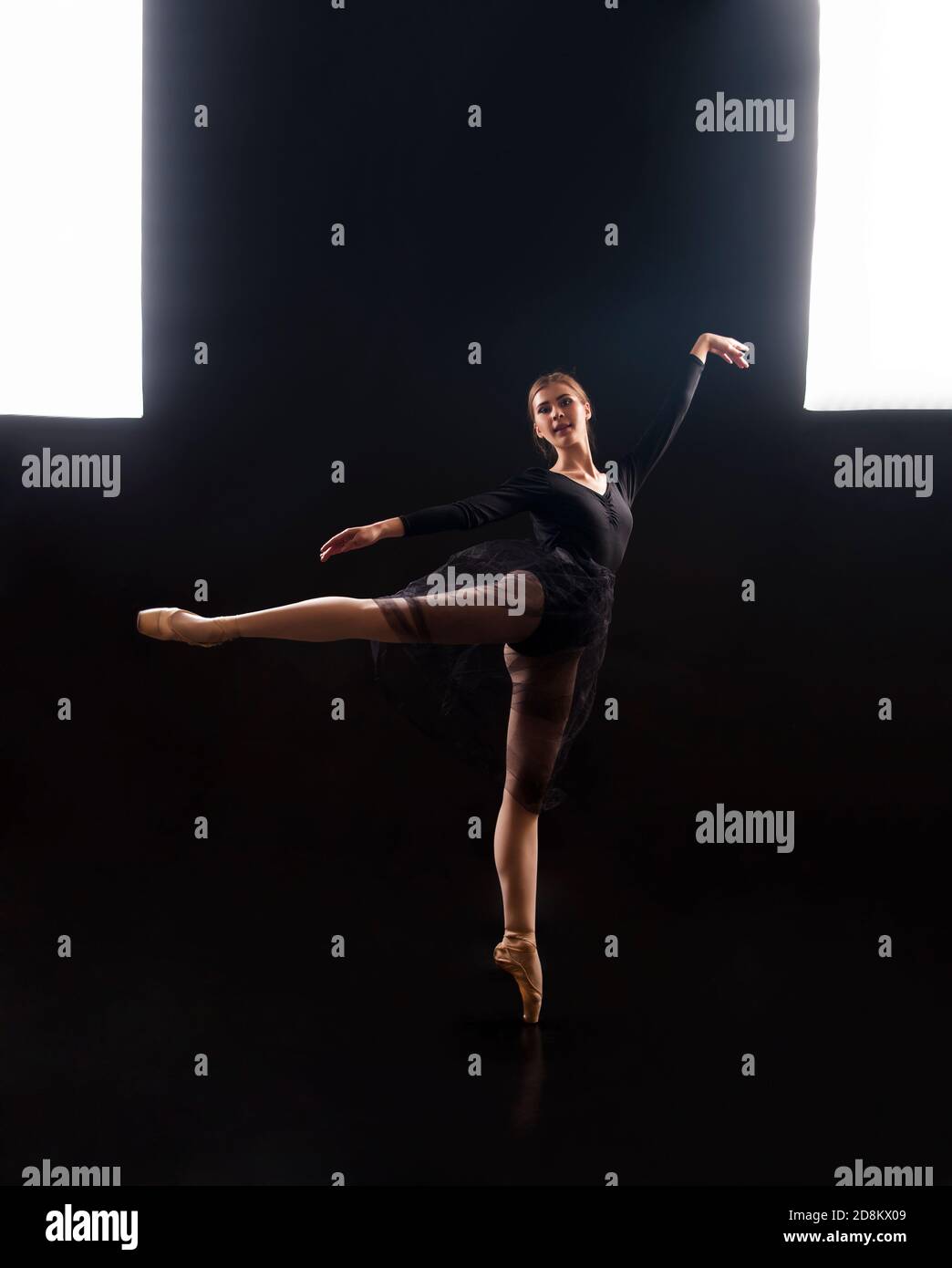 Charming woman ballerina in a black suit, is dancing a ballet in the ...