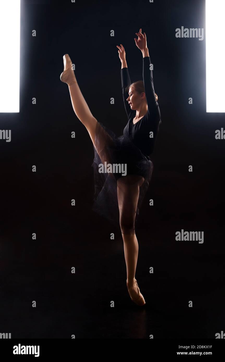 Charming woman ballerina in a black suit, is dancing a ballet in the ...