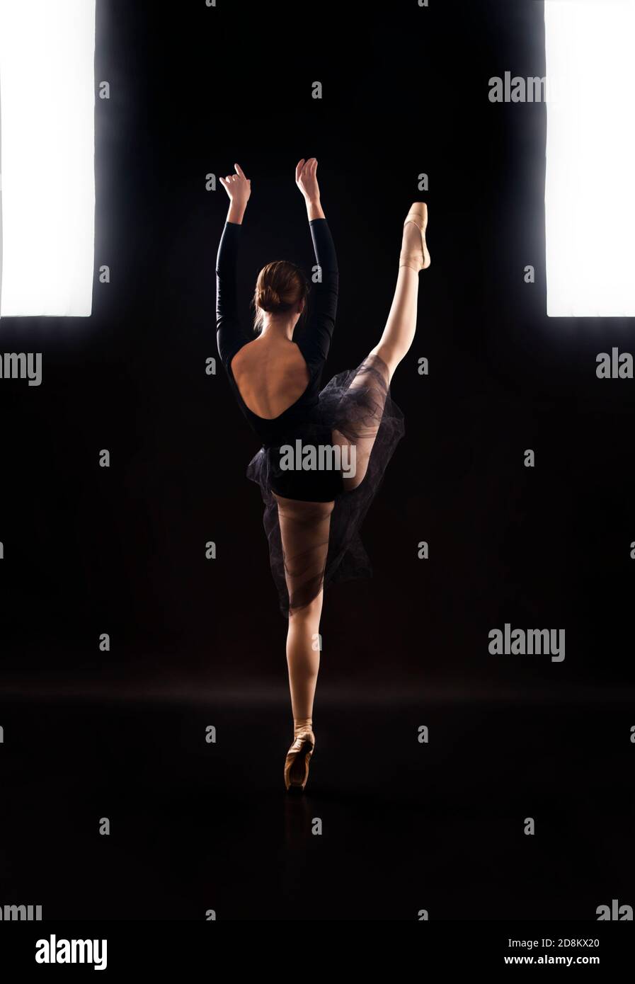 Charming woman ballerina in a black suit, is dancing a ballet in the ...