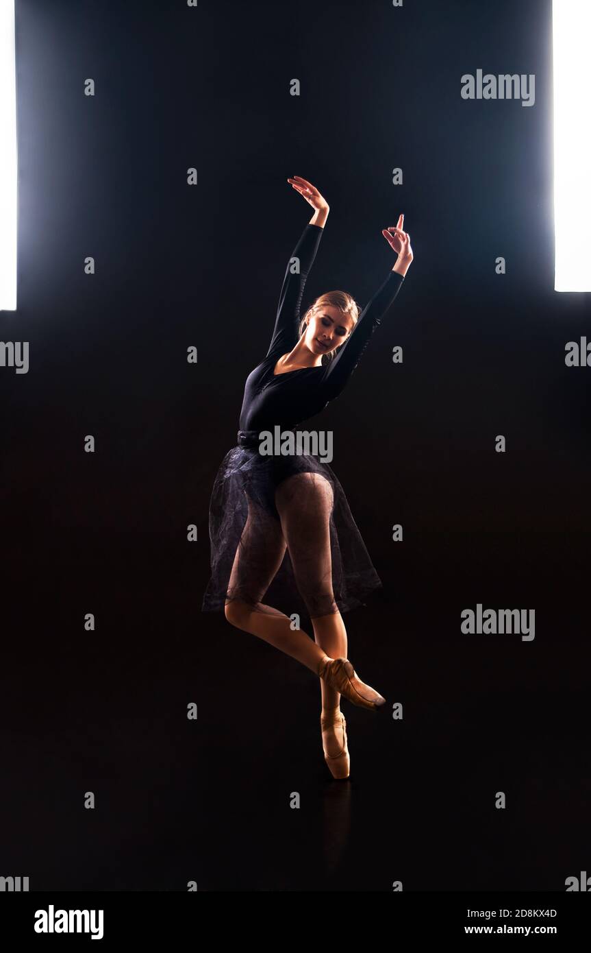 Charming woman ballerina in a black suit, is dancing a ballet in the ...