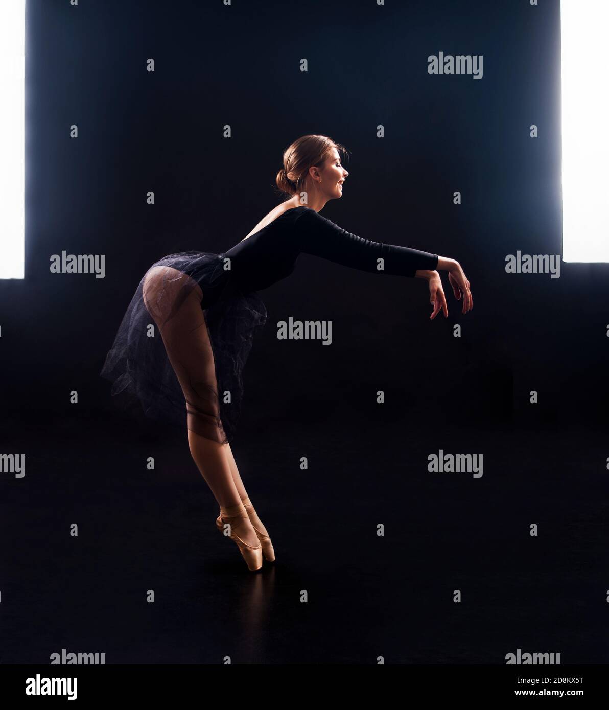 Charming woman ballerina in a black suit, is dancing a ballet in the ...