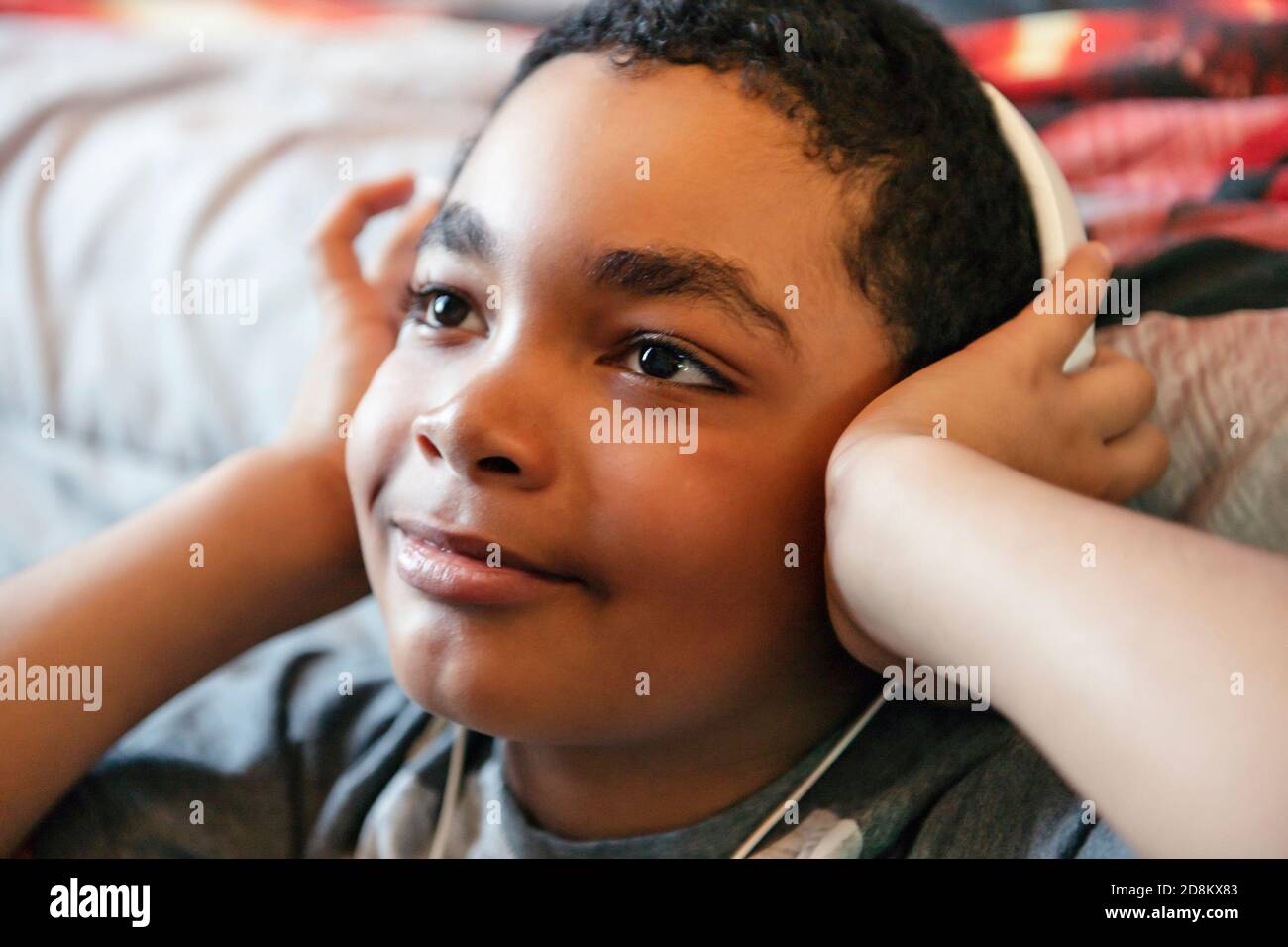 A Portrait of a sweet young boy listening to music on headphones Stock ...