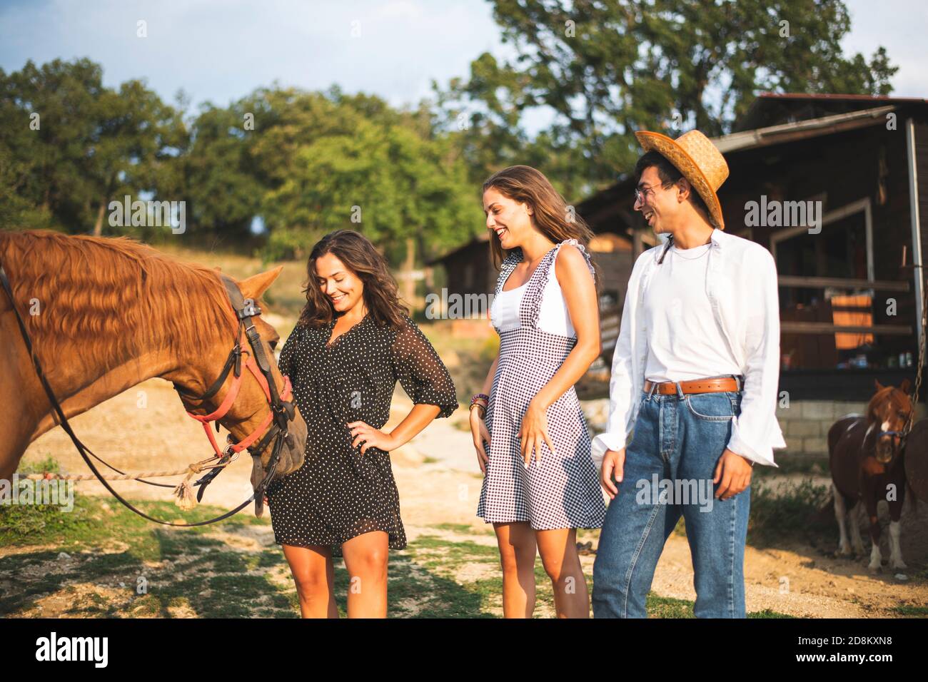 Three Friends Laughing and Having Fun in a Ranch with a Brown Horse ...