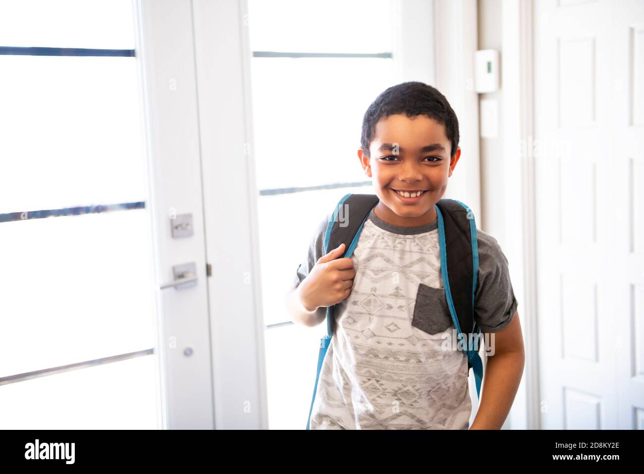 A child boy coming home passing through the door after school Stock ...